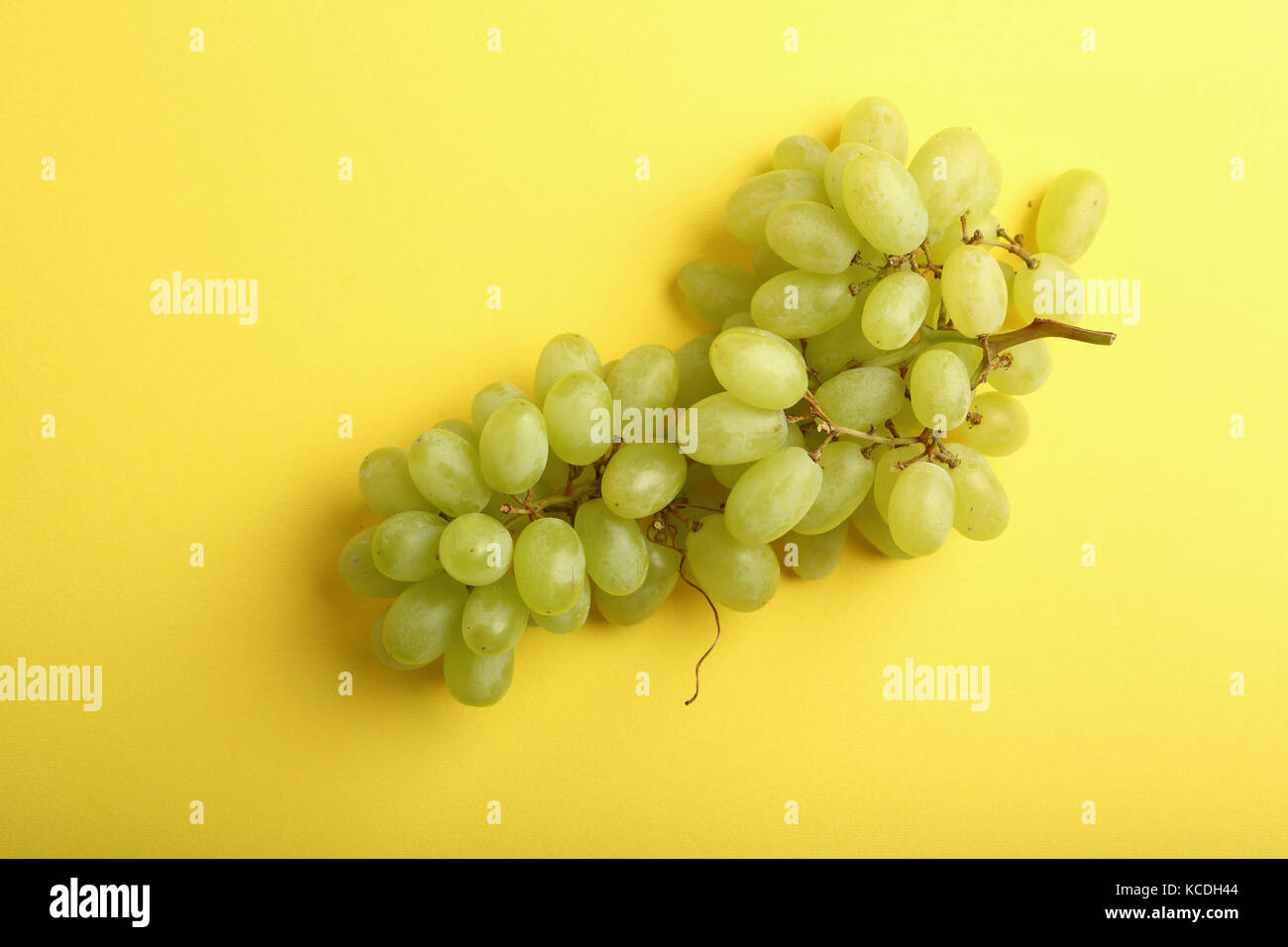 Bunch of grapes on yellow, food Stock Photo - Alamy