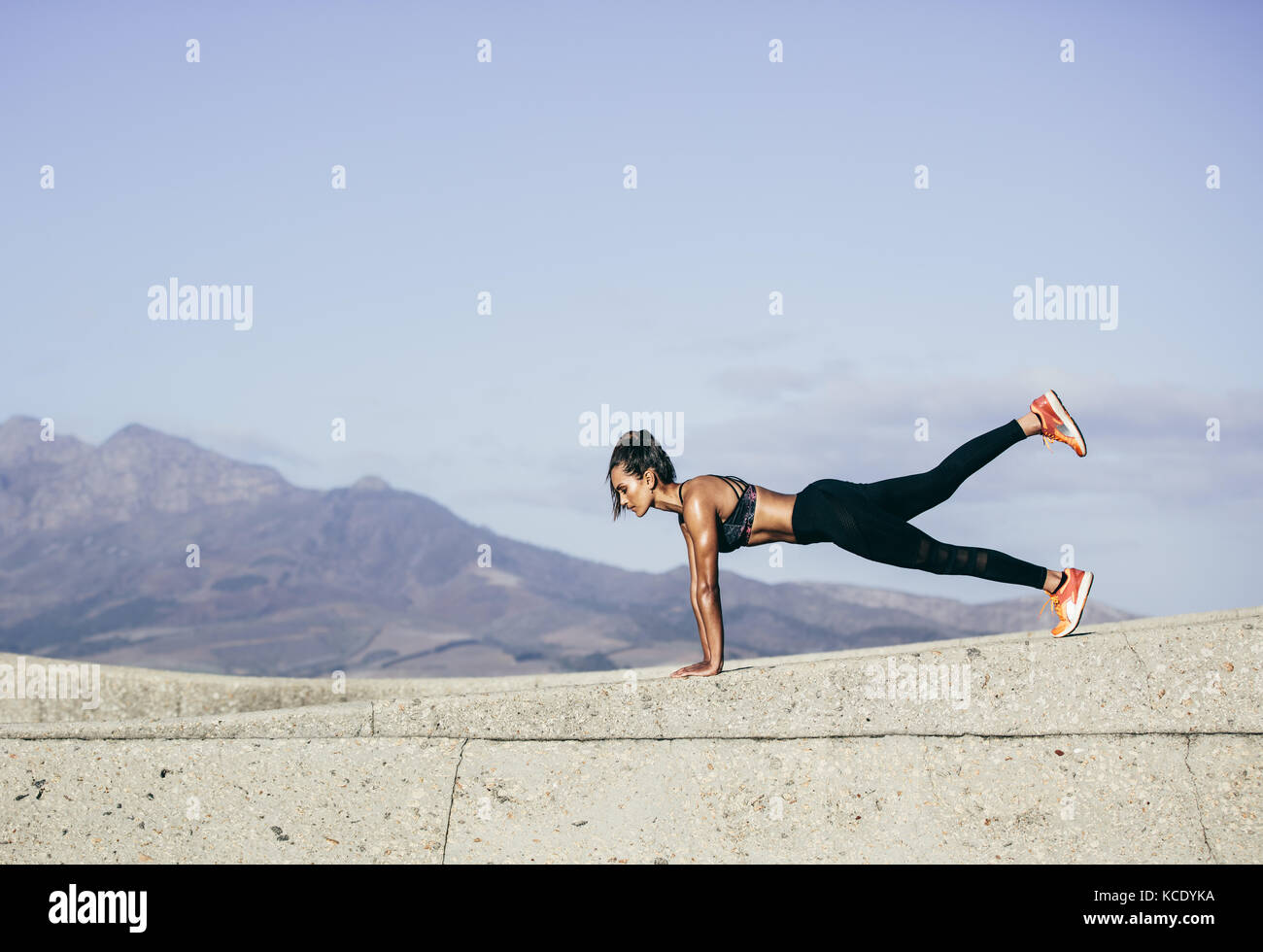 Muscular young woman doing push ups. Side view shot of healthy young ...