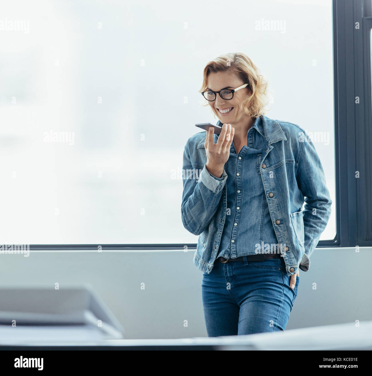 Female executive talking on speaker phone. Businesswoman speaking on ...