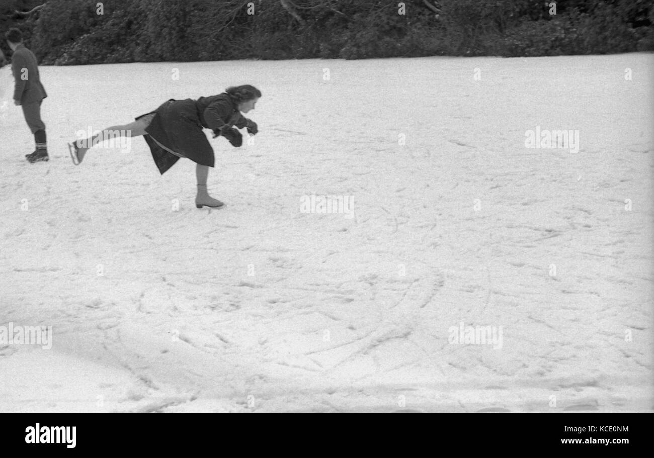 1950s, historical, lady wearing a coat and gloves ice skating on a ...