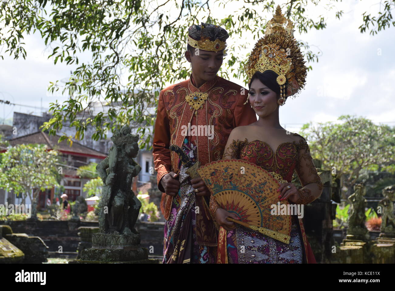 Balinese couple in traditional dress take wedding photos inside ...