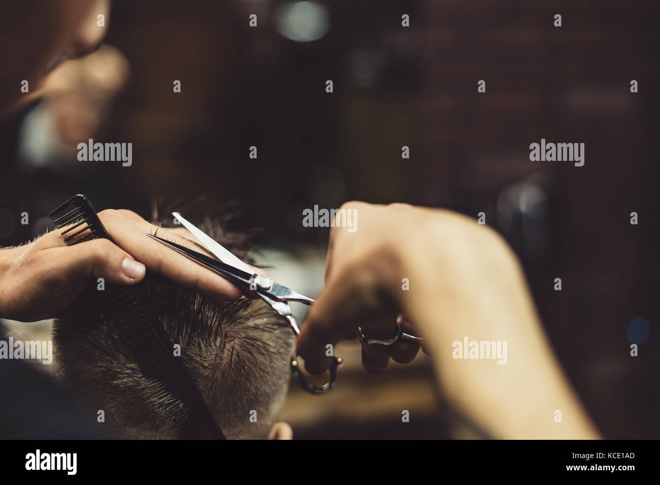 Crop barber doing haircut for client Stock Photo - Alamy