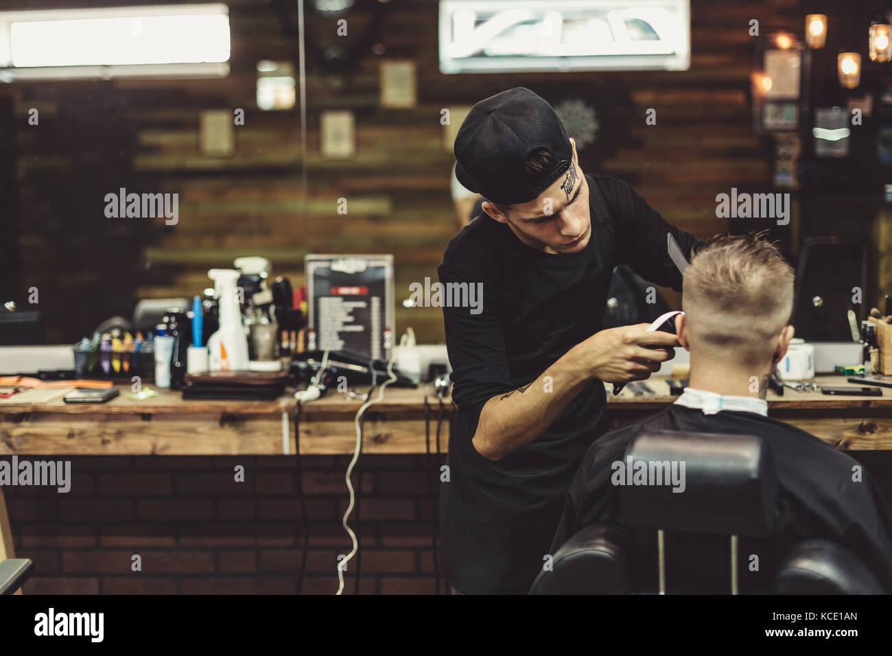 Crop barber doing haircut for client Stock Photo - Alamy