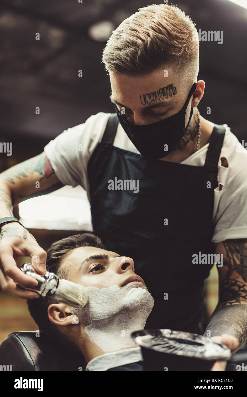 Barber shaving client Stock Photo - Alamy