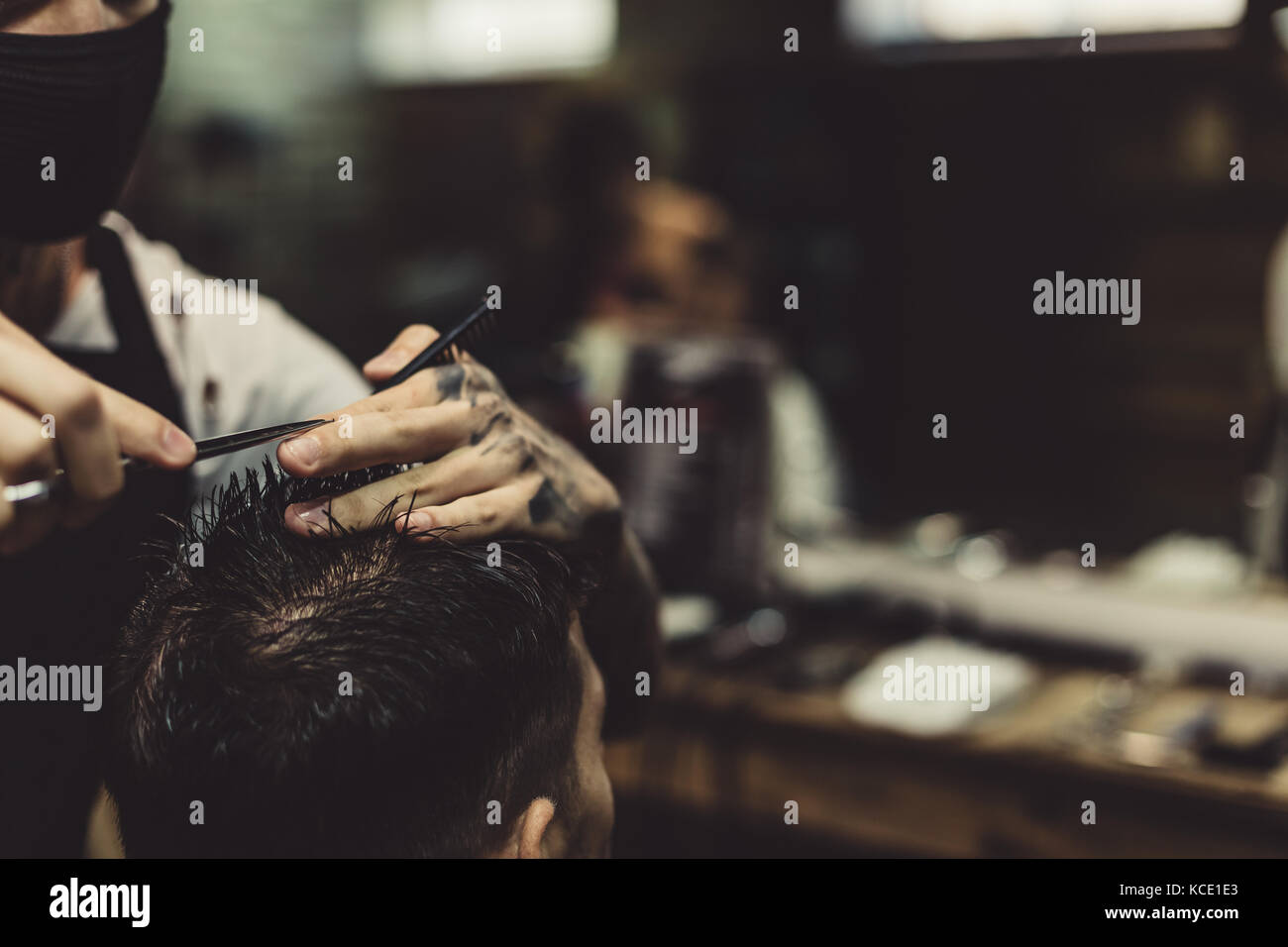 Crop barber doing haircut for client Stock Photo - Alamy