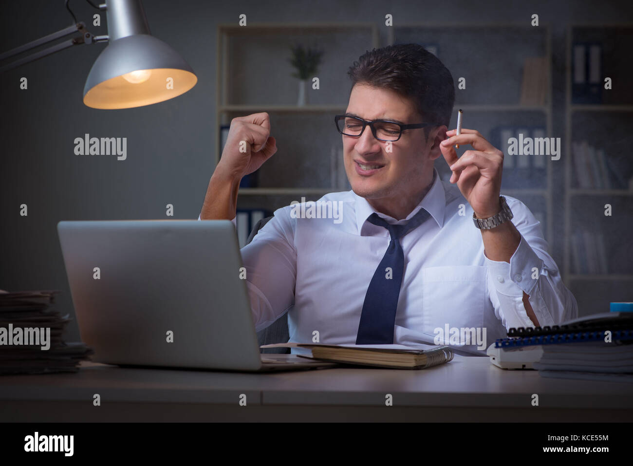 Businessman under stress smoking in office Stock Photo - Alamy