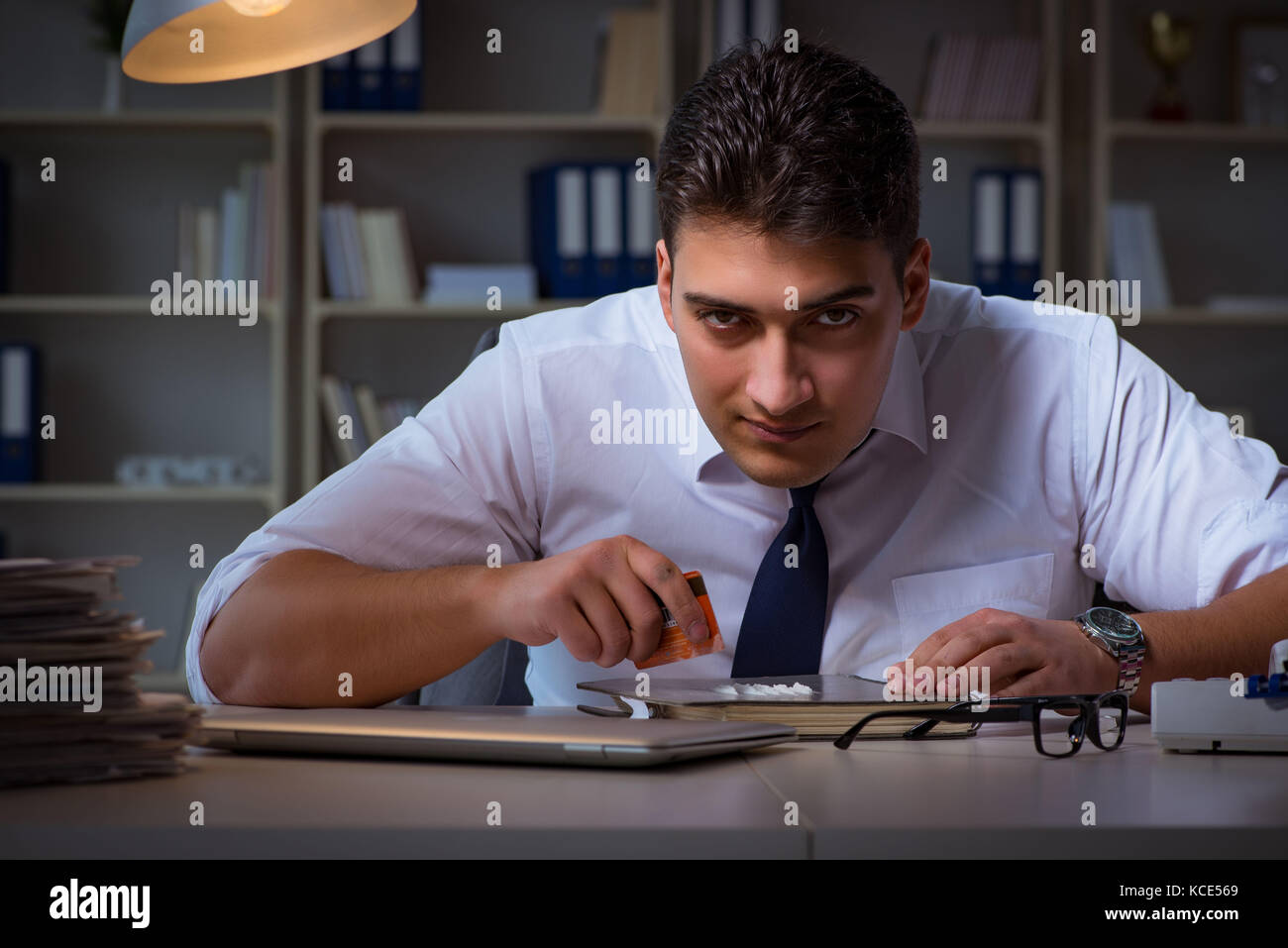 Businessman staying late in office for drugs Stock Photo - Alamy