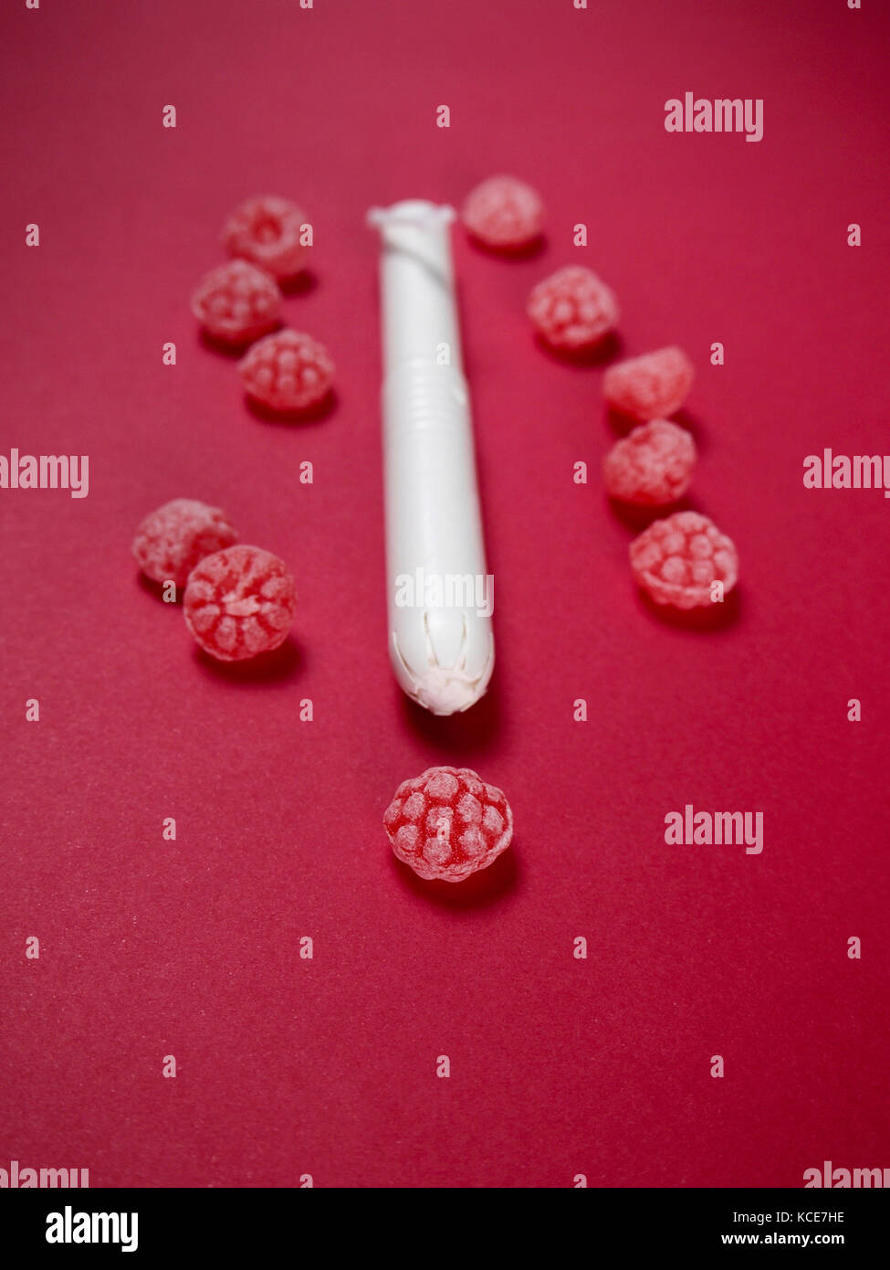 Tampon with red candies on red background Stock Photo - Alamy