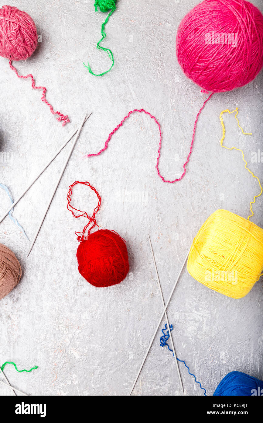 Multicolor knitting ball and needles on grey background. Top view. Copy ...