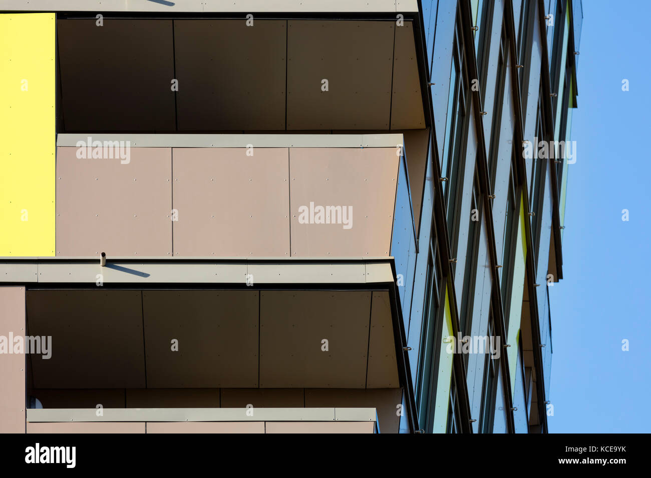 Patterns of windows, balconies and acid yellow cladding on a 13-storey ...