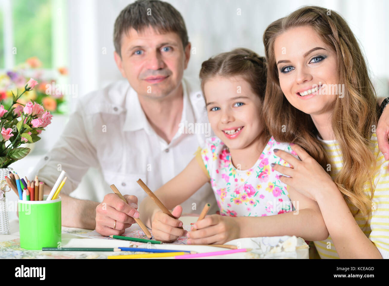 Portrait of happy parents drawing with their daughter together Stock ...