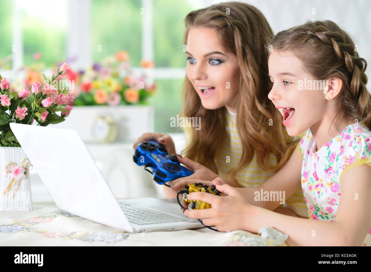 mother and daughter playing computer game on laptop together Stock ...