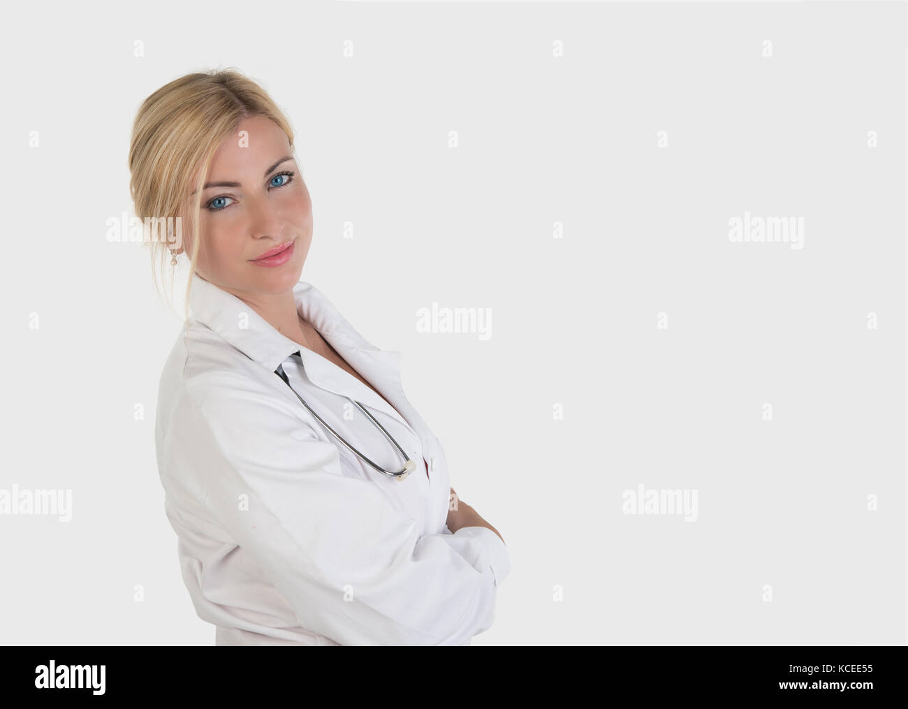 Young female blonde doctor with blue eyes, posing on white background ...