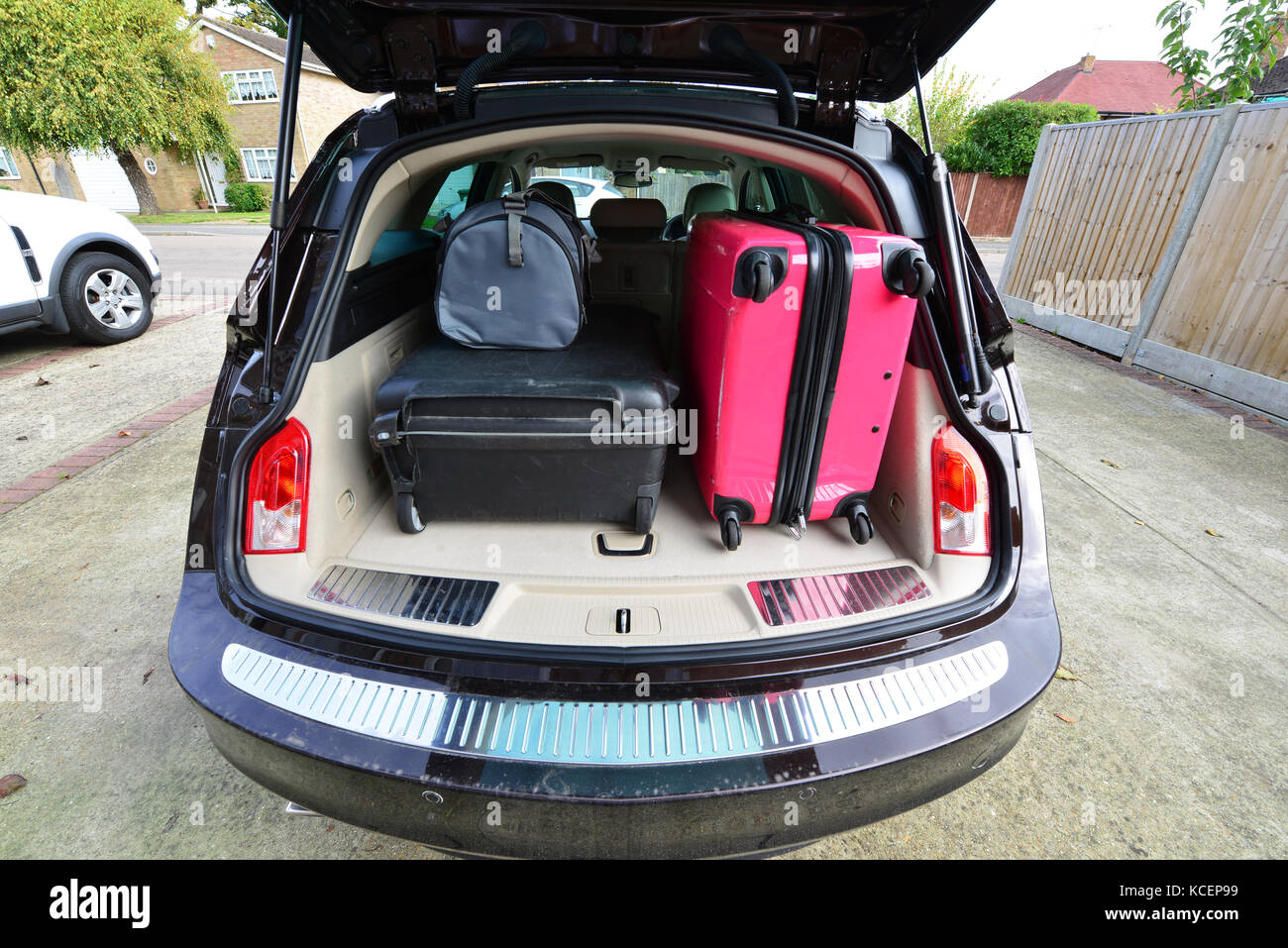 Suit cases packed for a holiday into an estate car Stock Photo - Alamy