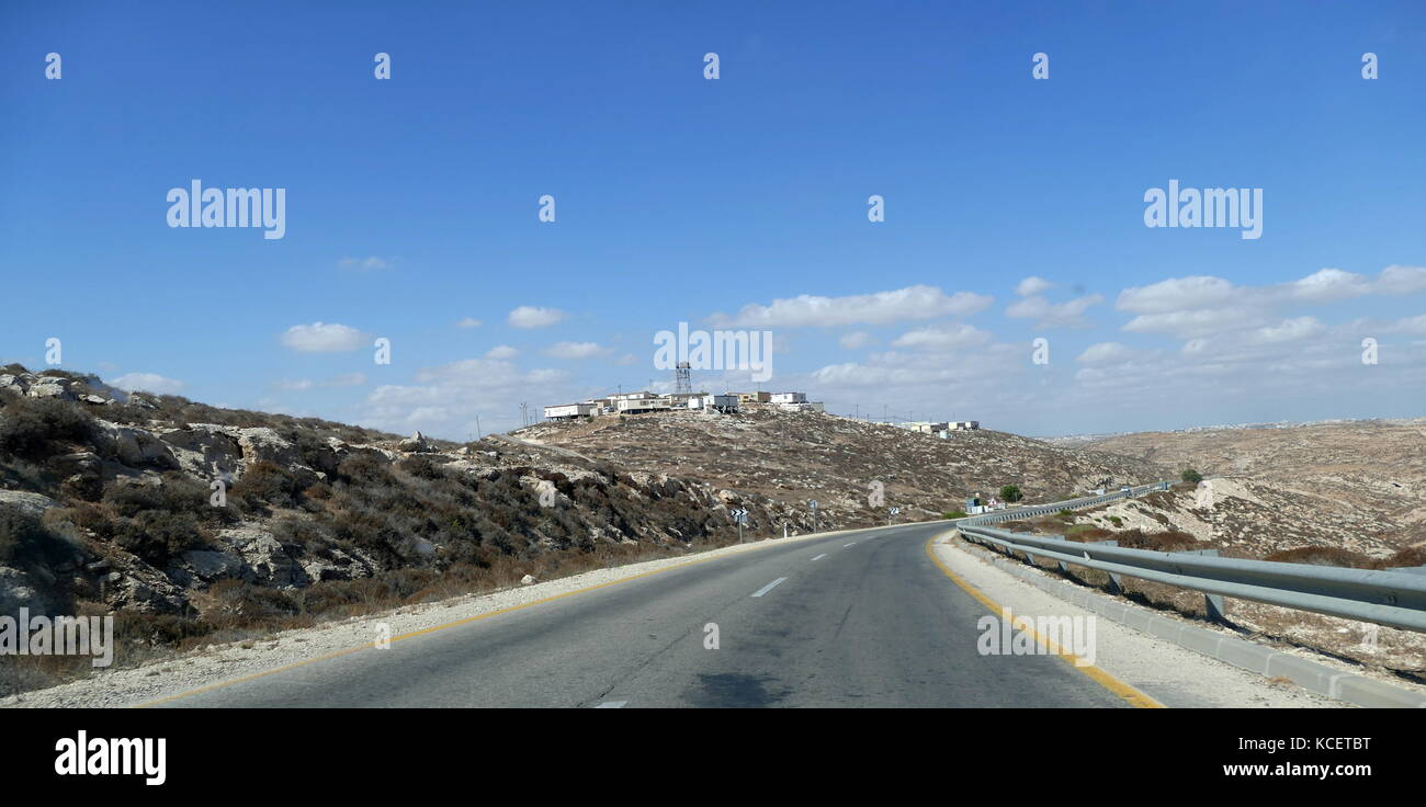 A newly built road passes below a Jewish Settlement in the West bank of ...