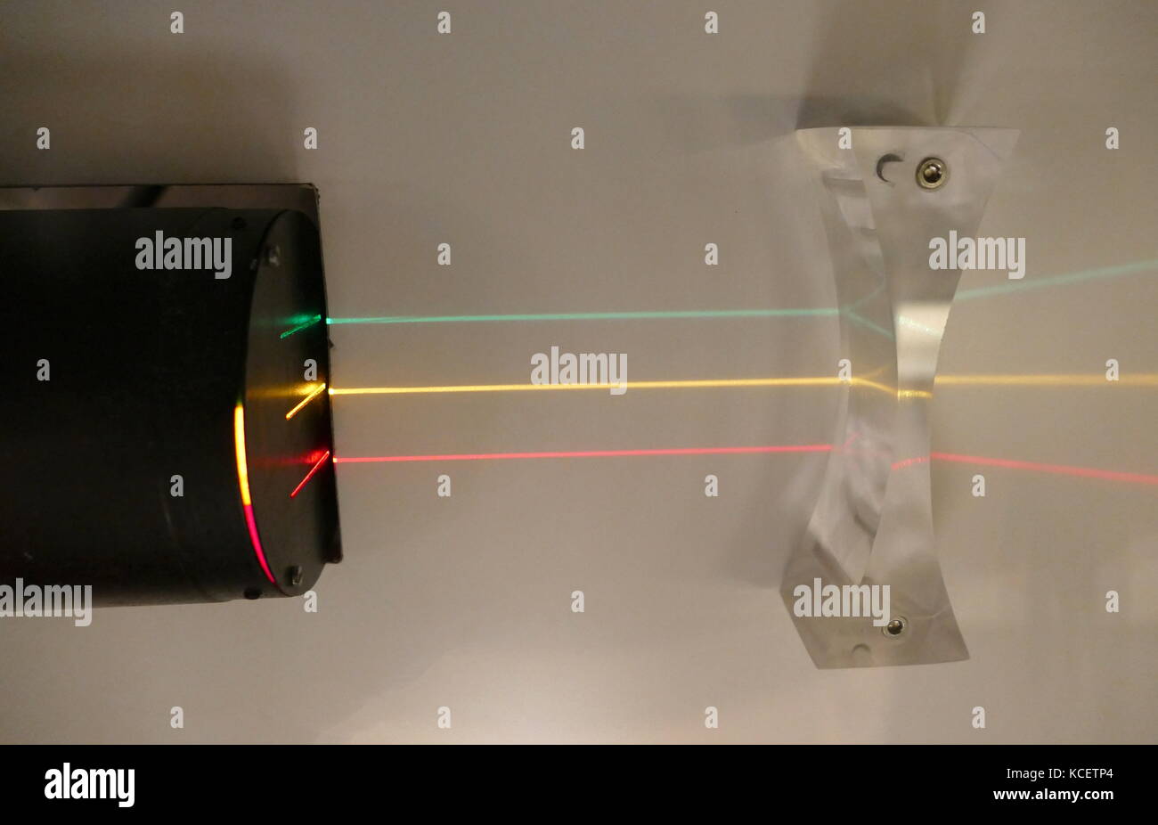 three parallel beams of light are refracted through a concave Lens. A ...