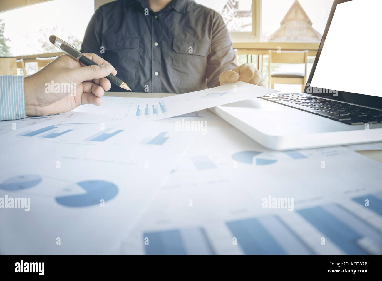 Two businessmen looking at report and having a discussion in office ...