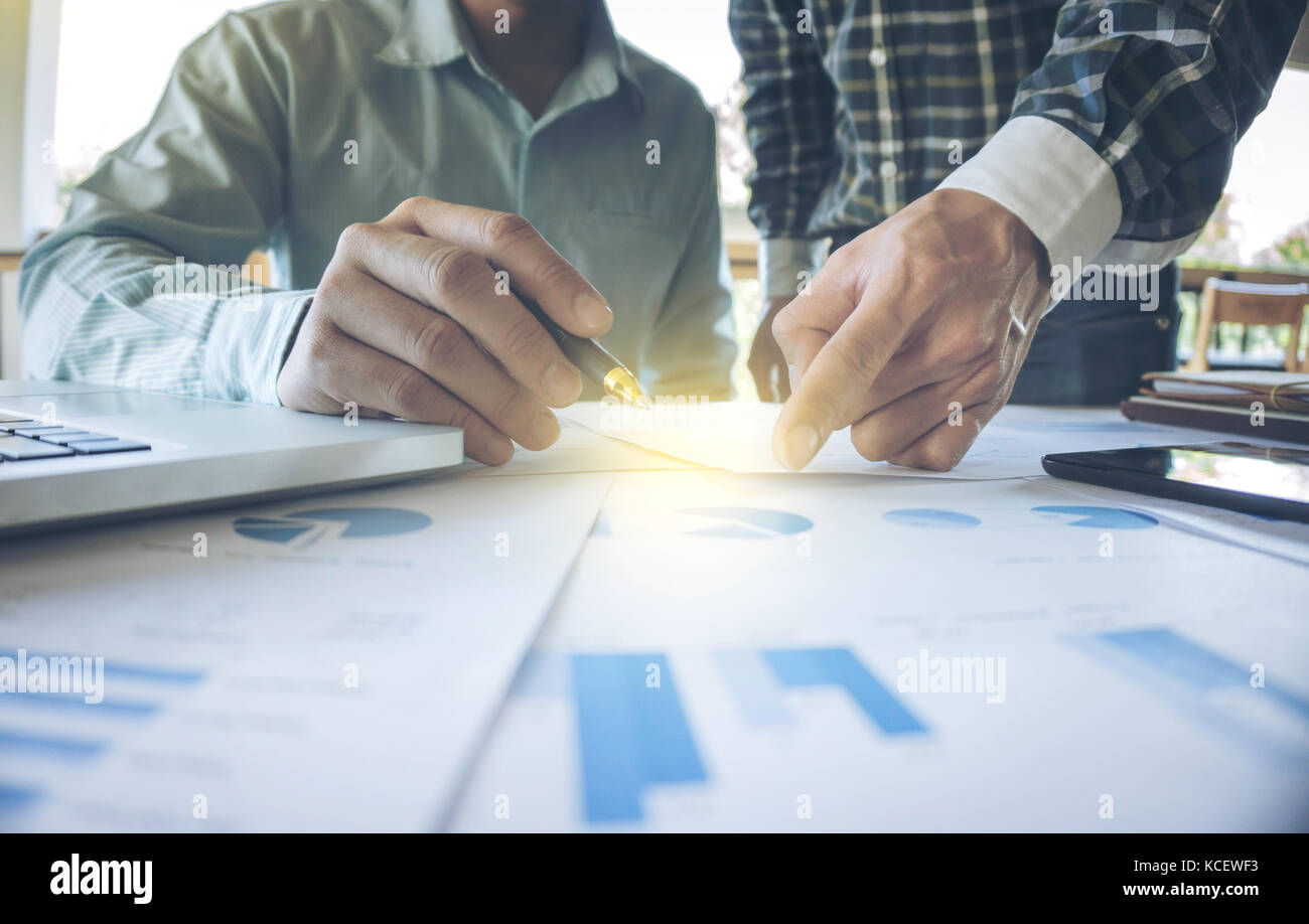 Two businessmen looking at report and having a discussion in office ...