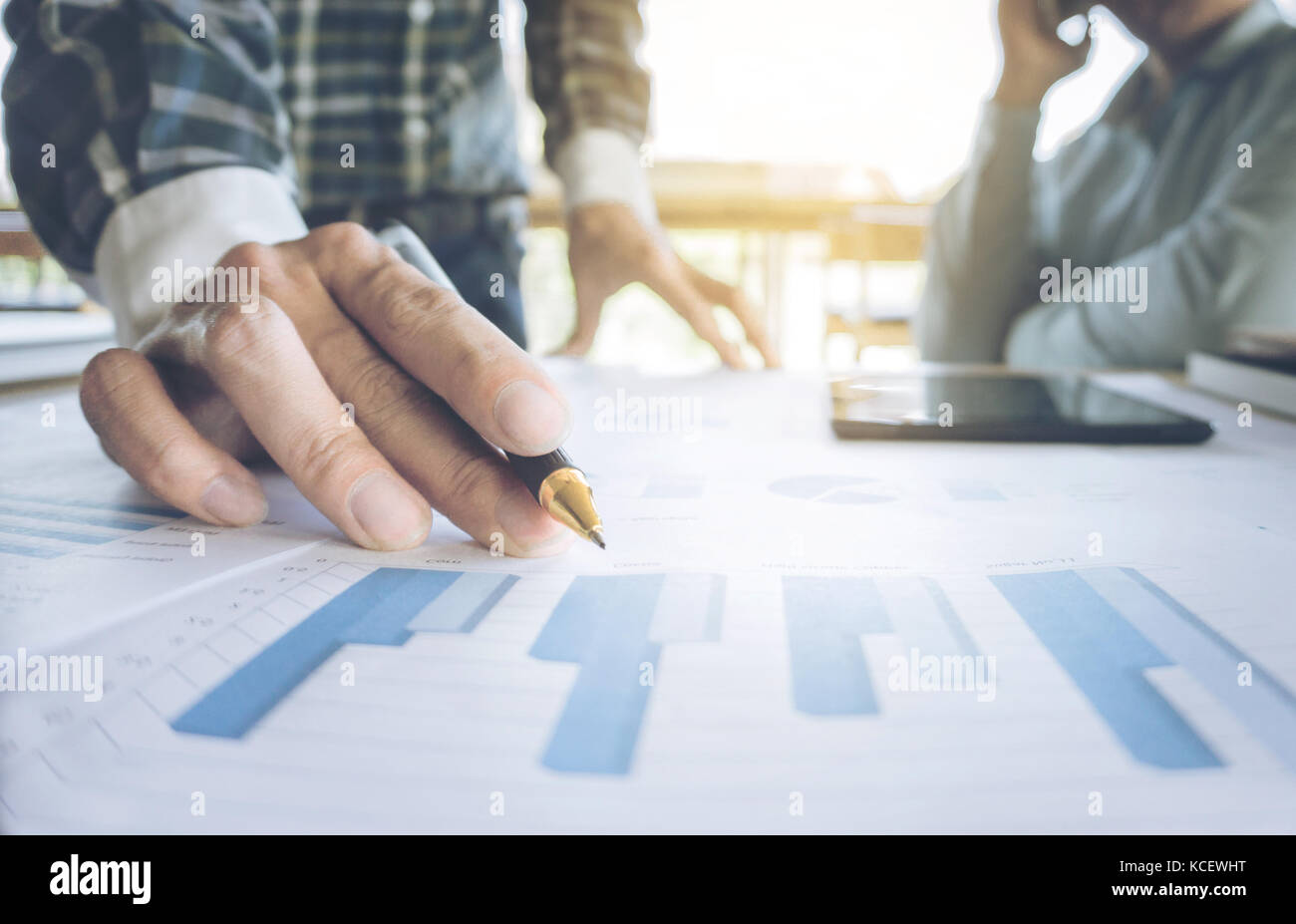 Two businessmen looking at report and having a discussion in office ...