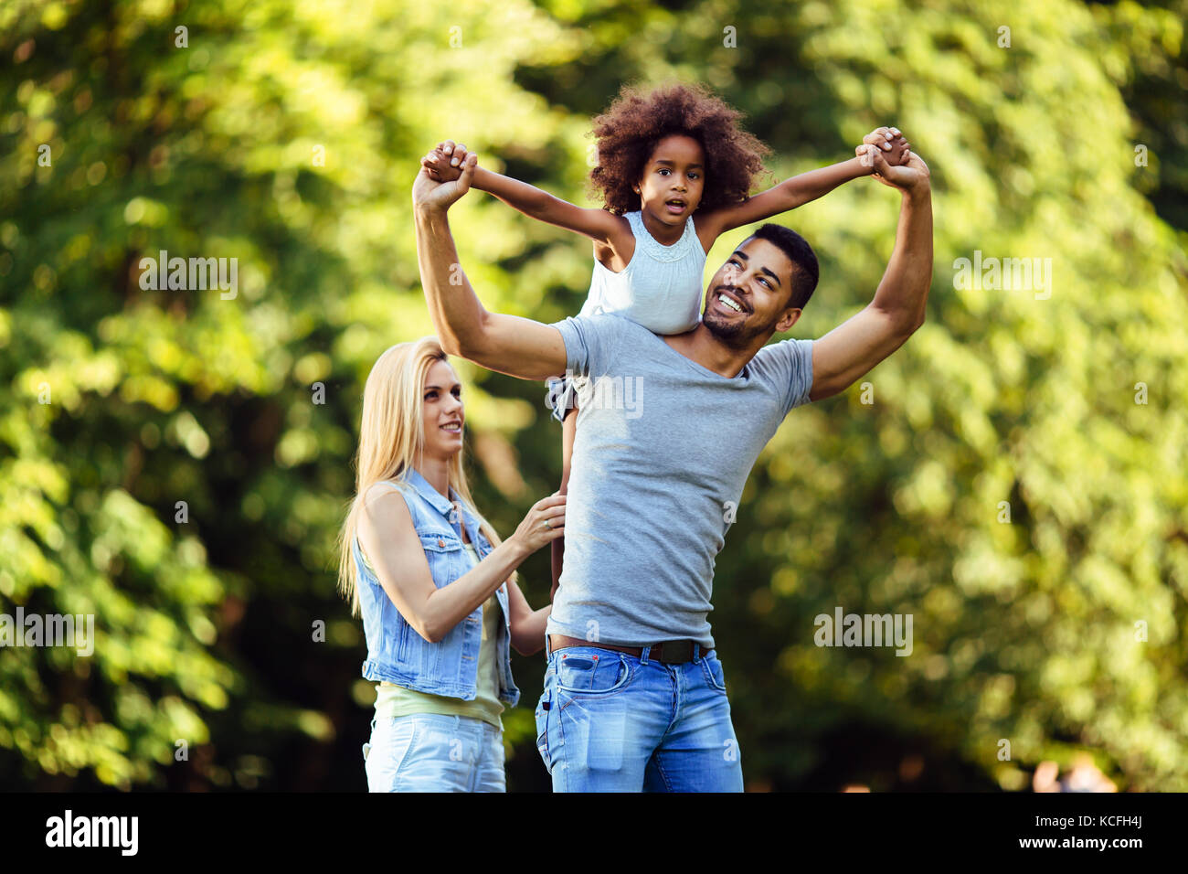 Picture of happy young couple spending time with their daughter Stock ...