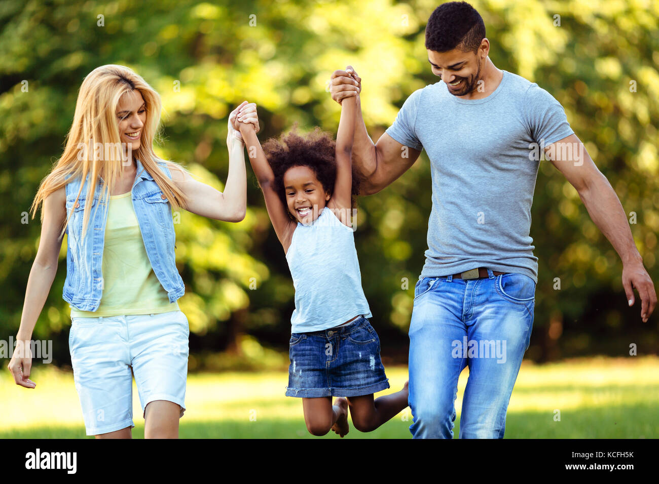 Happy young couple spending time with their daughter Stock Photo - Alamy