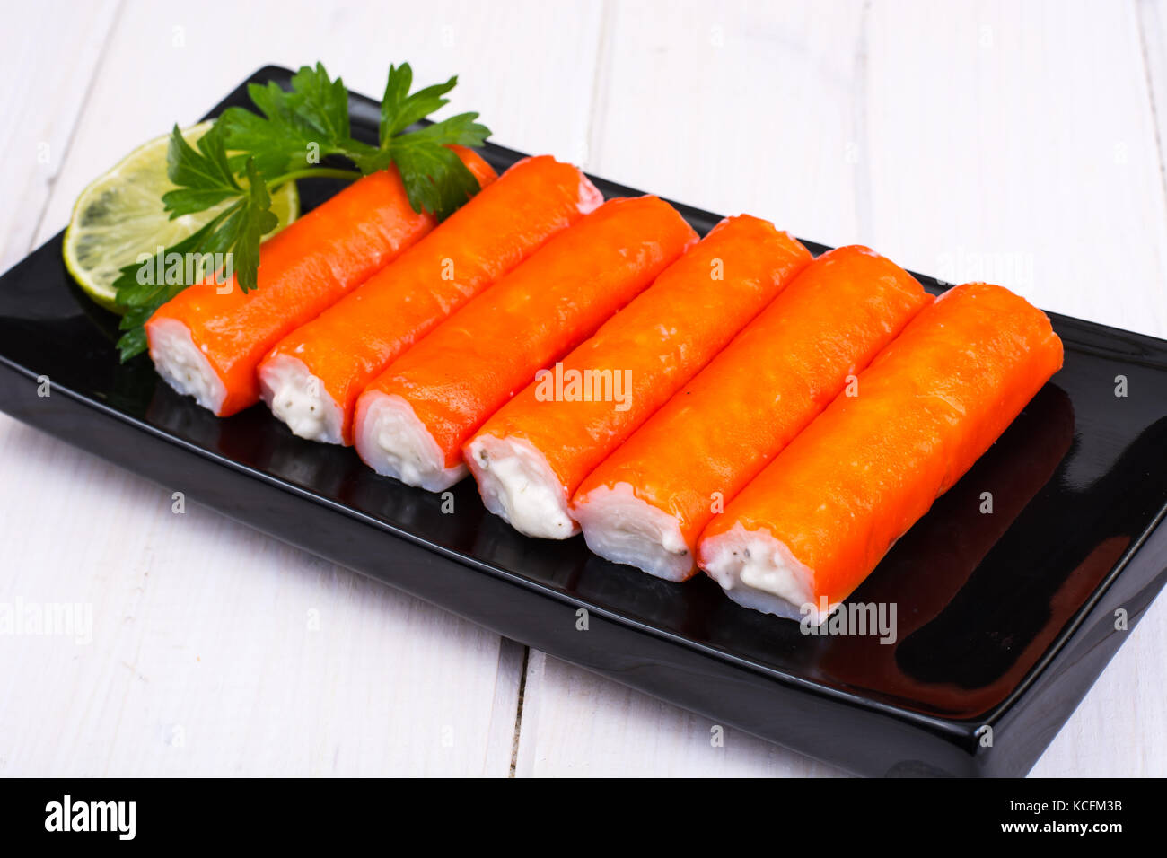 Surimi-crab sticks on black plate Stock Photo - Alamy