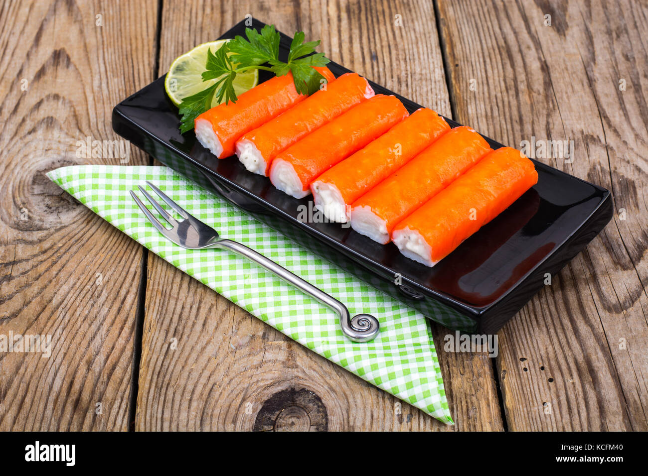 Surimi-crab sticks on black plate Stock Photo - Alamy