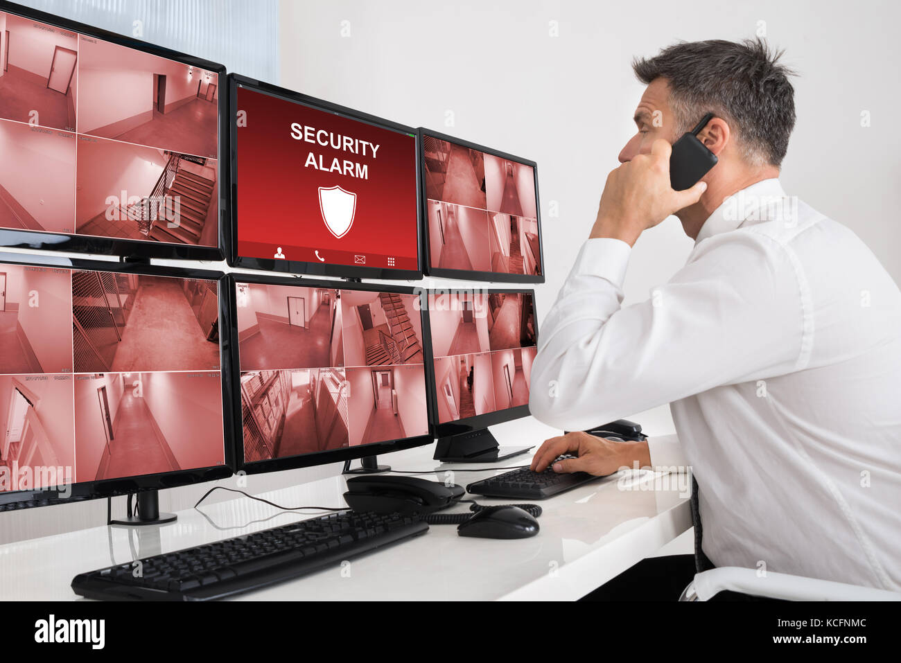 Male Operator Using Walkie-talkie While Monitoring Multiple CCTV ...