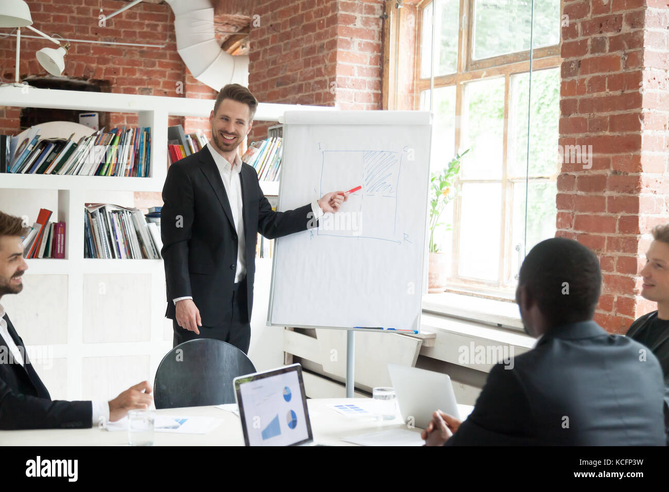 Smiling CEO consulting business team about new workflow during briefing ...