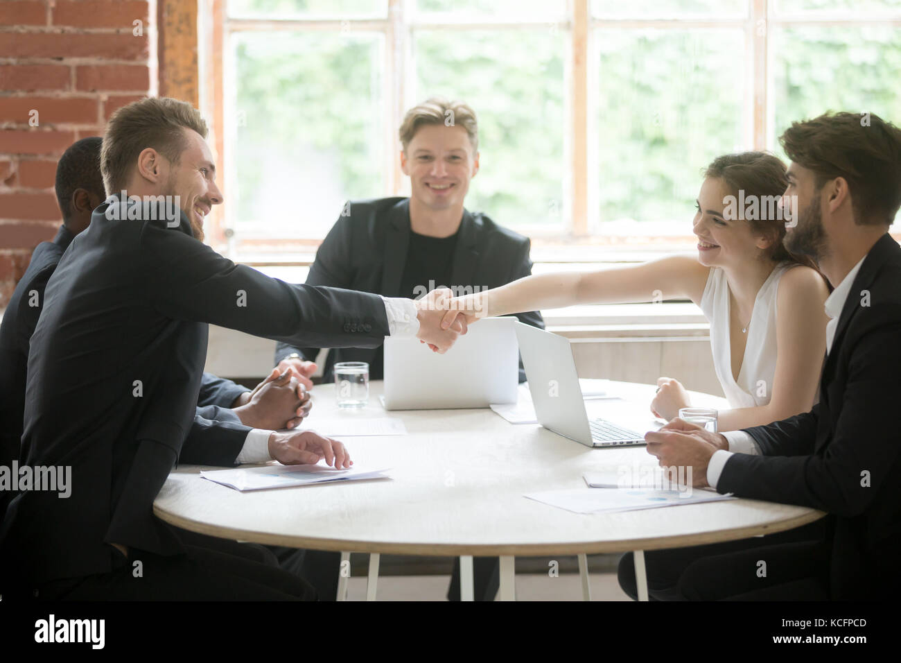 Corporate coworker meeting. Male executive shaking hands with female ...