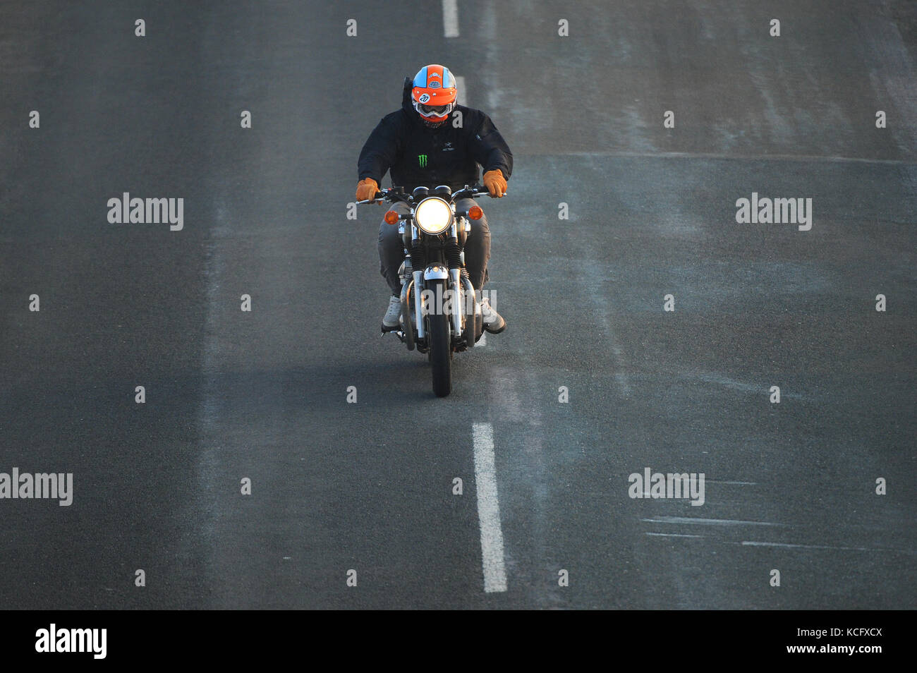 A man rides the TT course on the Isle of Man on a vintage motorbike ...