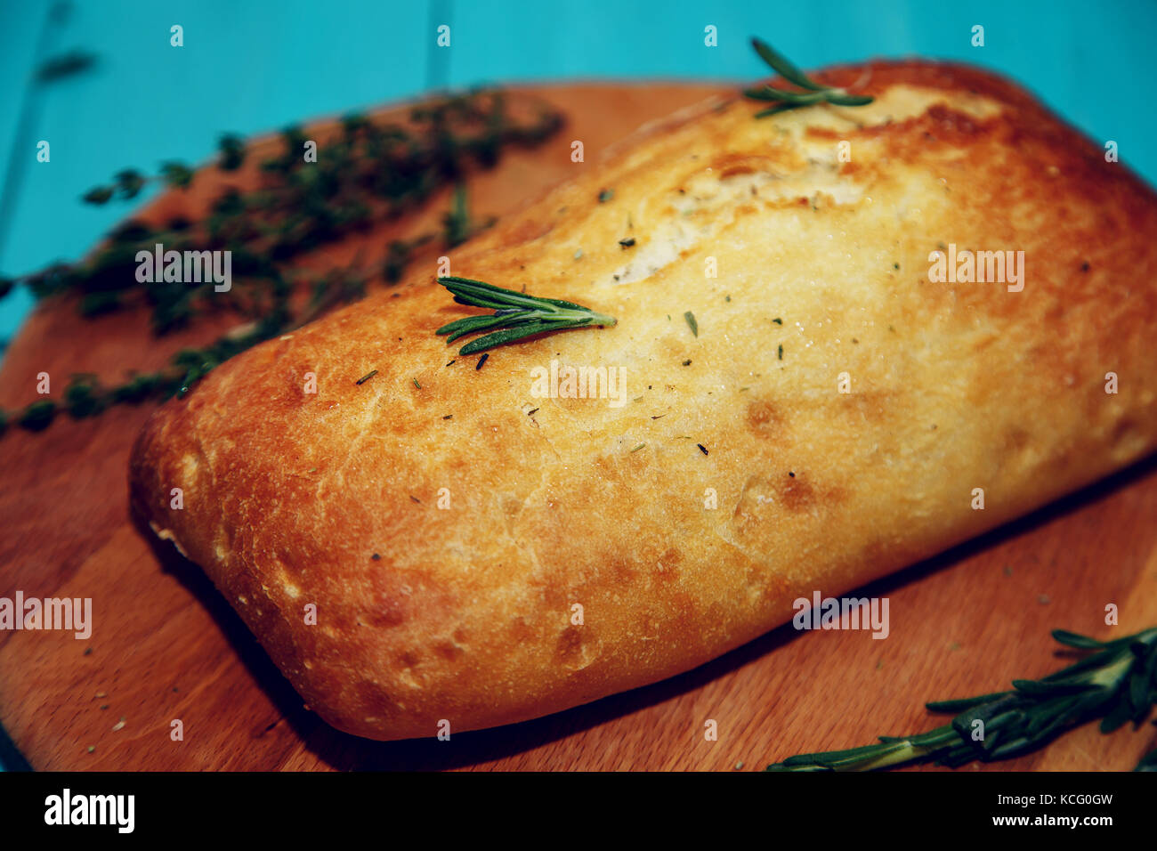 Traditional Italian ciabatta bread with herbs. Blue wooden background ...