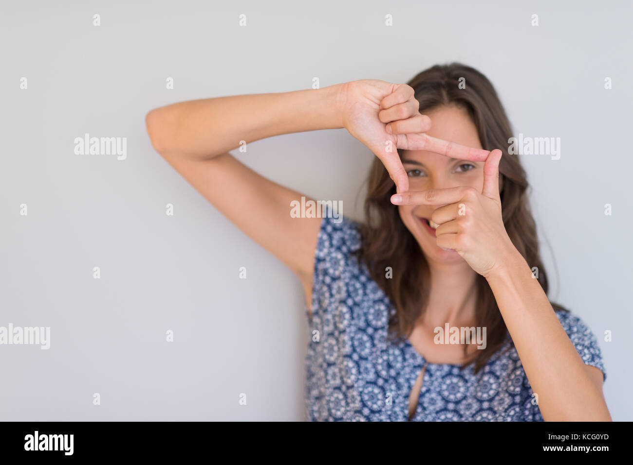young happy woman showing framing hand gesture isolated on a white ...
