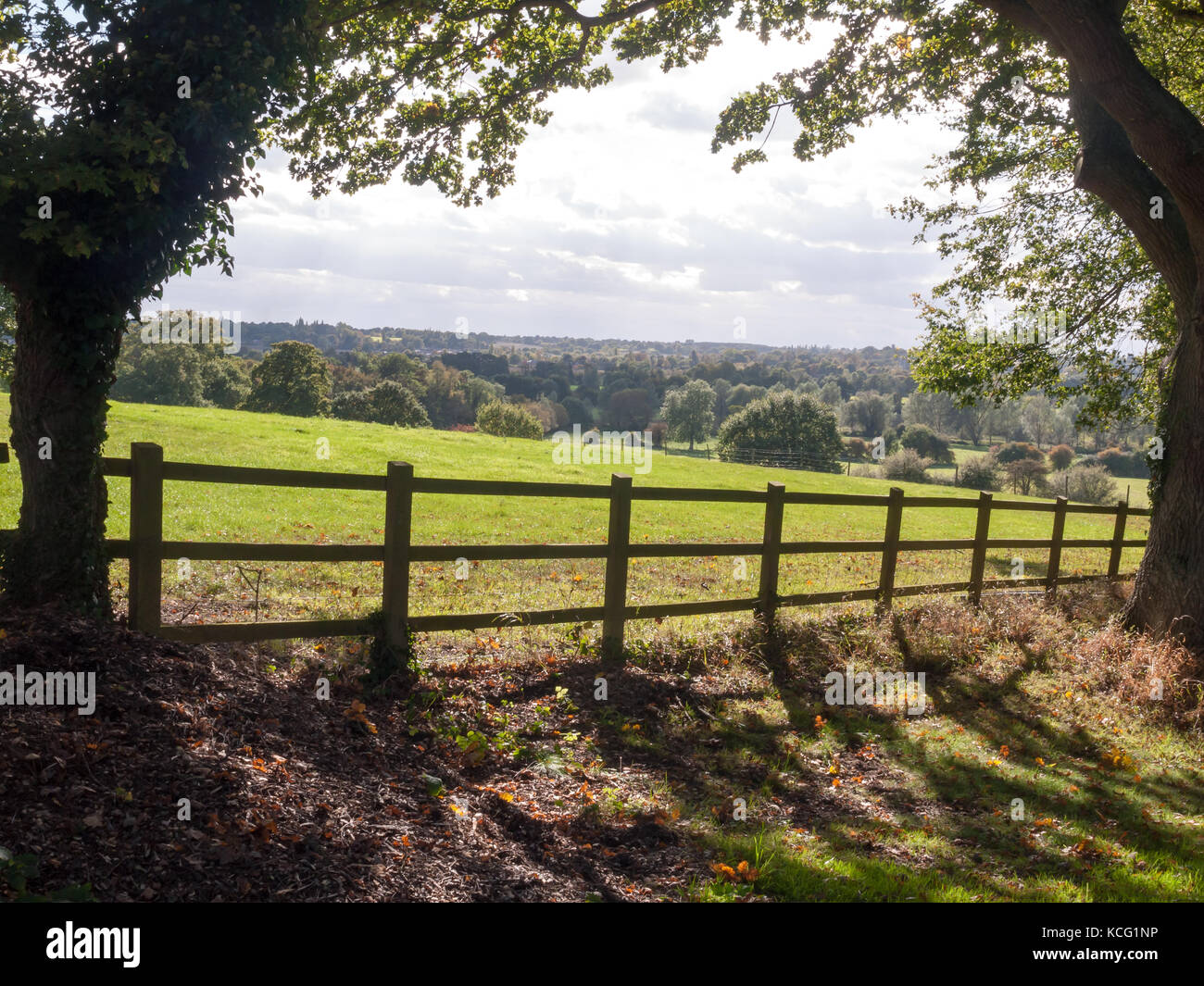 country side open rolling fields below with wooden fence up front ...