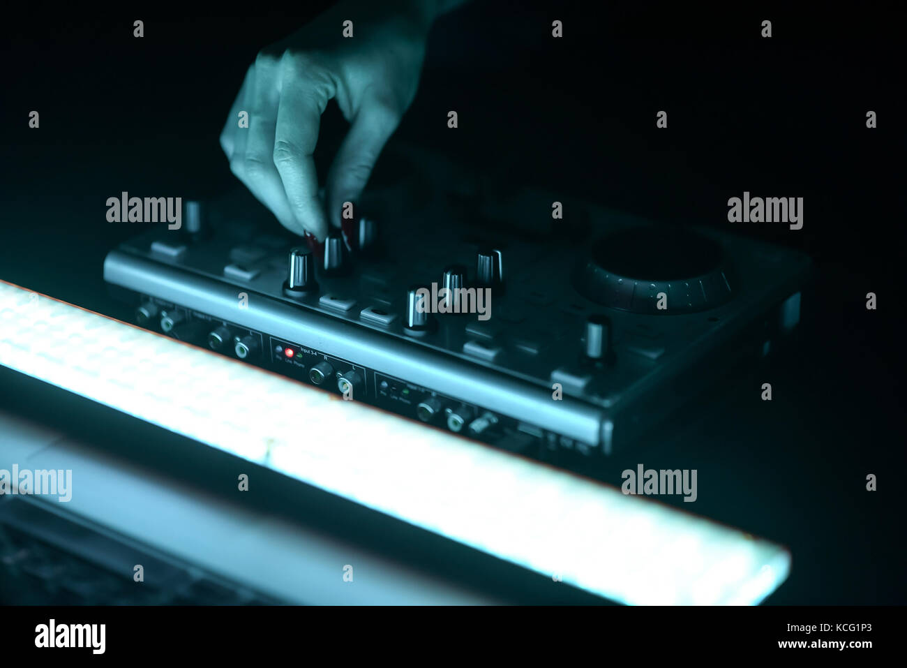 DJ mixer disco illuminated by searchlights Stock Photo - Alamy