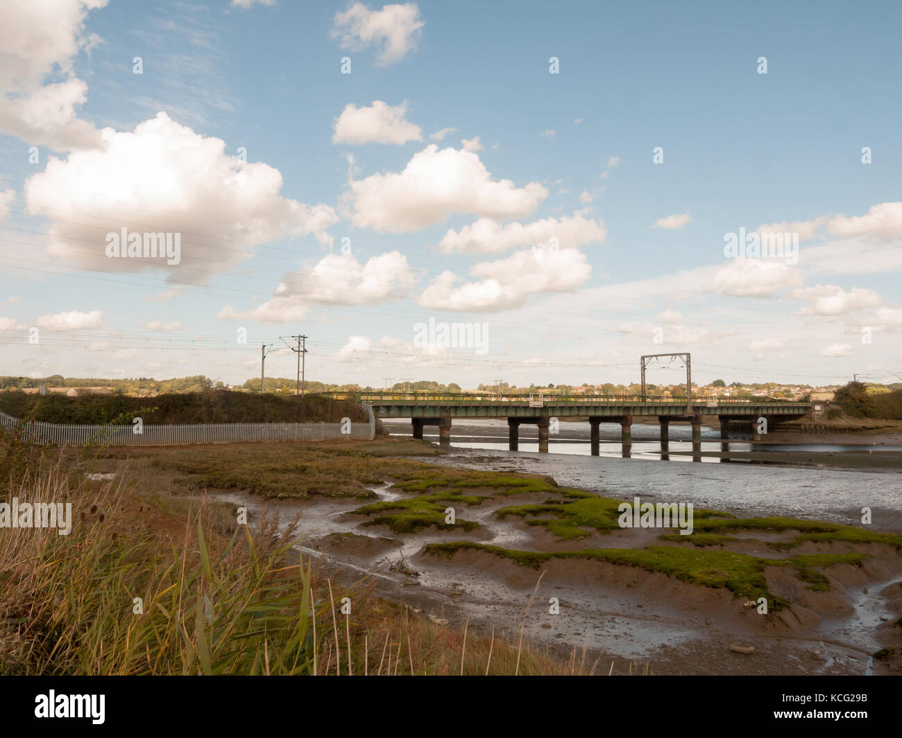 old unused bridge in the distance above estuary stream countryside ...
