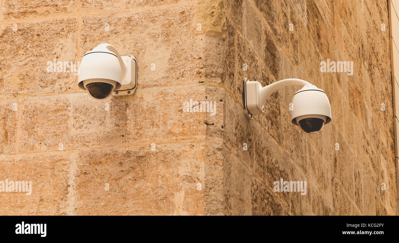 white CCTV surveillance camera on a stone wall Stock Photo - Alamy