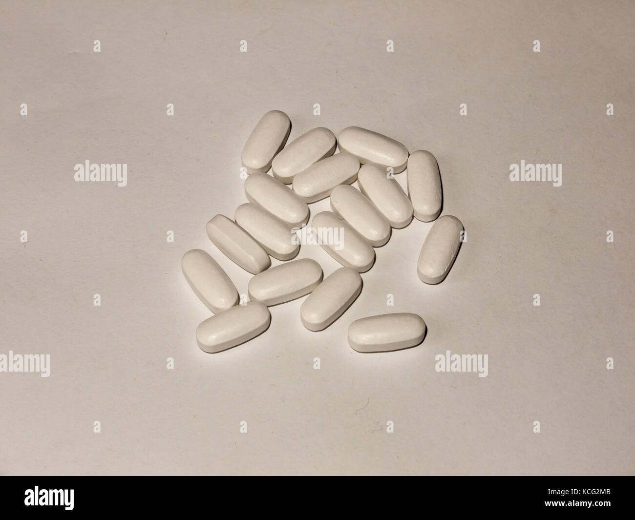 many white generic tablet pills on a white background; Essex; England ...