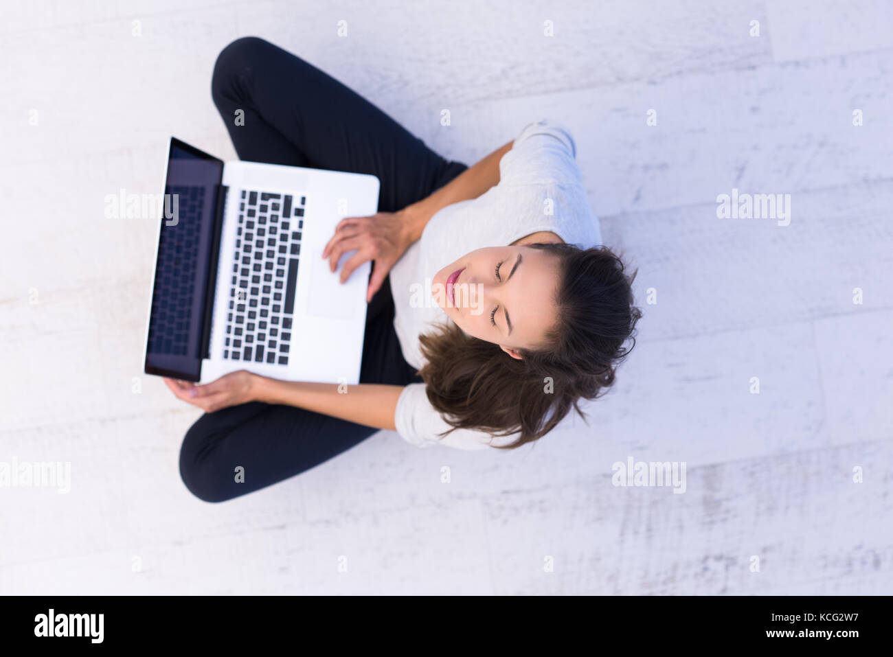top view of a beautiful young women using laptop computer on the floor ...