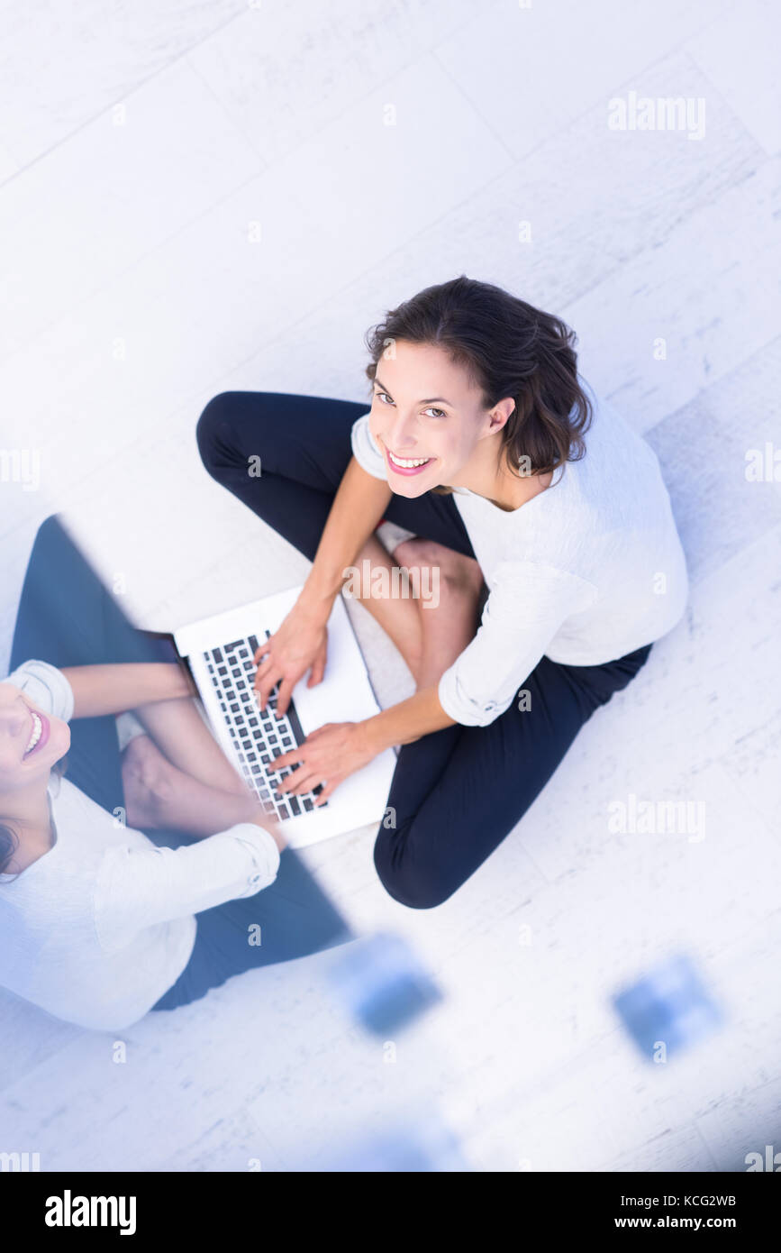 top view of a beautiful young women using laptop computer on the floor ...