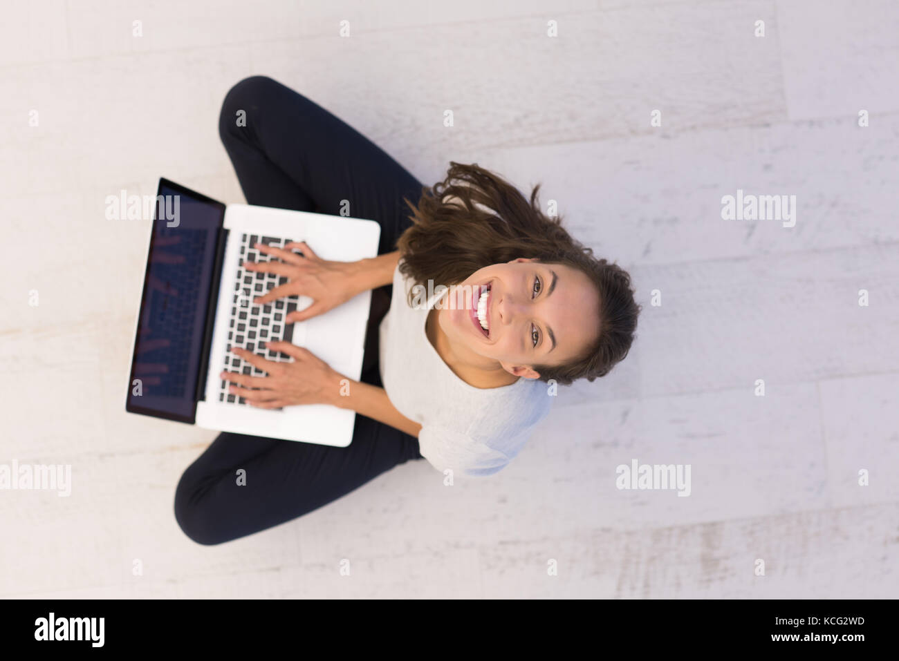 top view of a beautiful young women using laptop computer on the floor ...