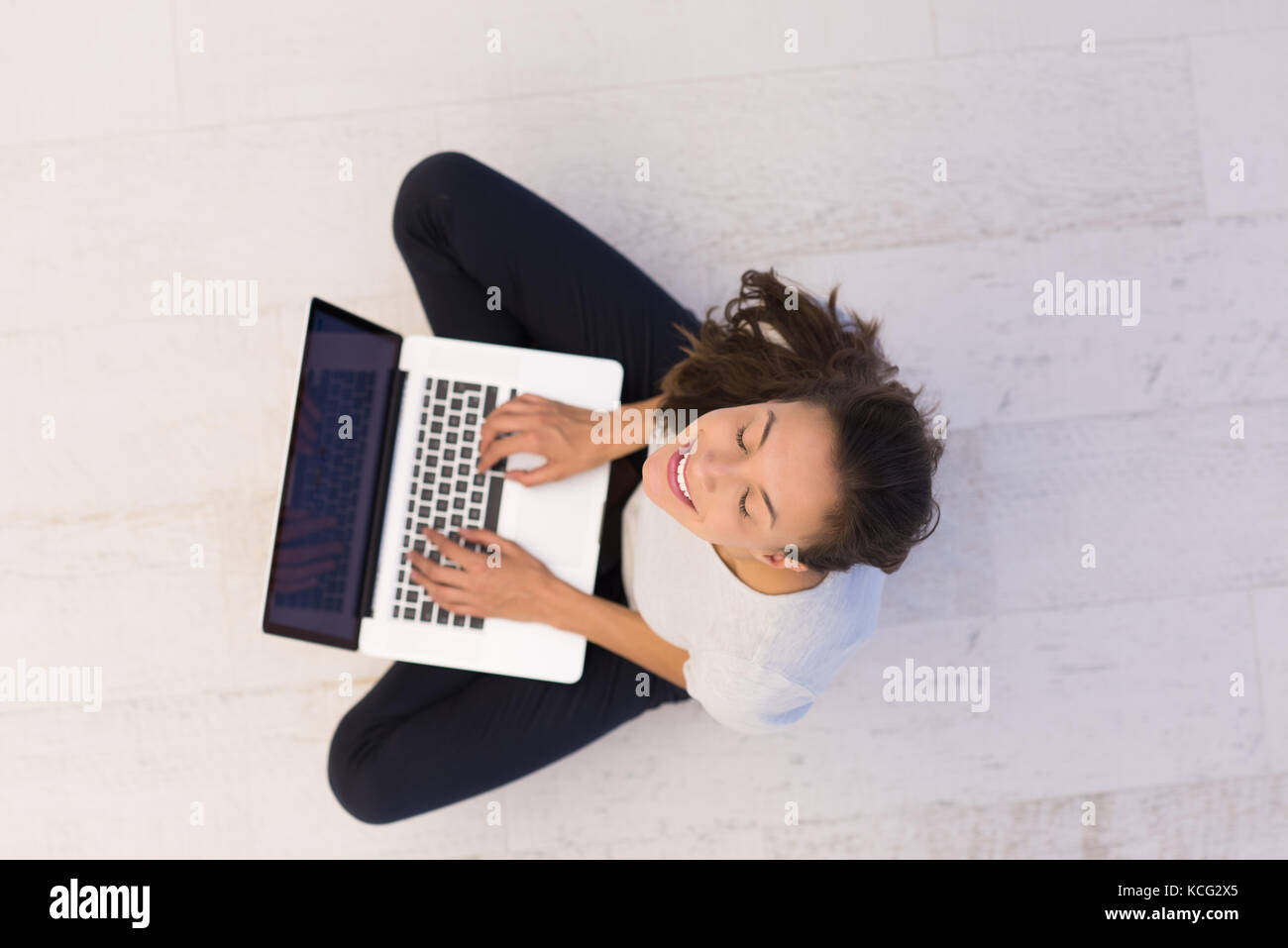 top view of a beautiful young women using laptop computer on the floor ...