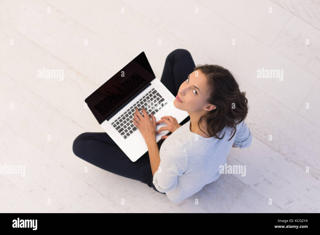 top view of a beautiful young women using laptop computer on the floor ...