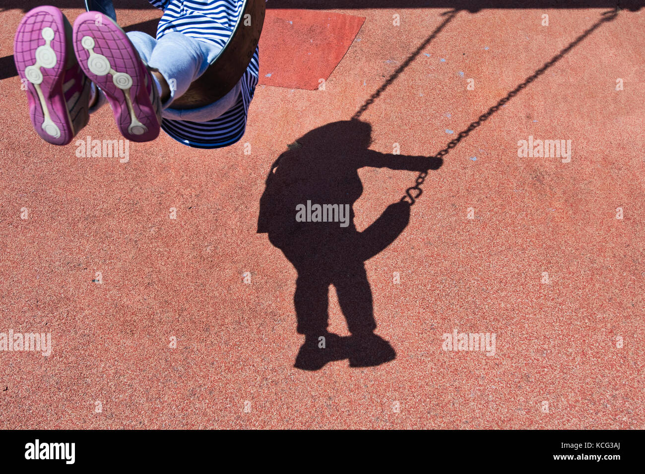 Shadow playing on a swing Stock Photo - Alamy
