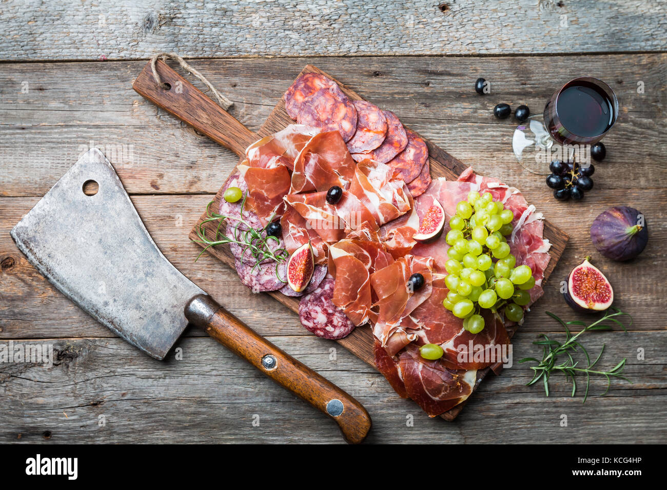 Sliced jamon on cutting board with fig , grapes and red wine. Parma ham ...