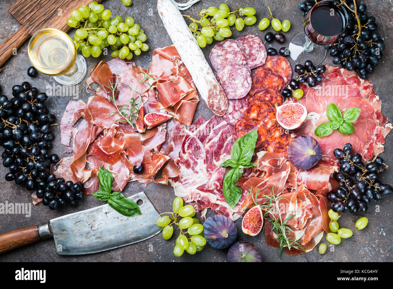 Different types jamon on cutting boardes with figs, grapes and wine ...