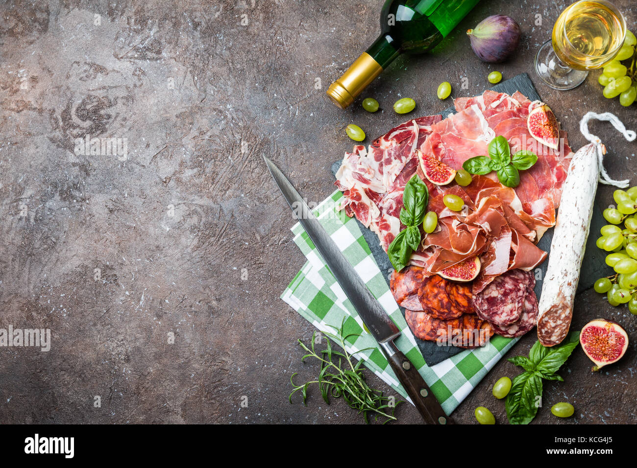 Sliced jamon on cutting board with fig , grapes and white wine. Parma ...