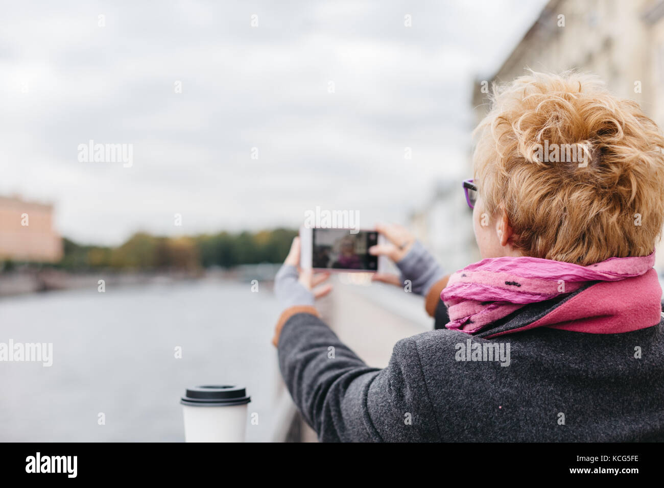 Woman taking shots from waterfront Stock Photo - Alamy