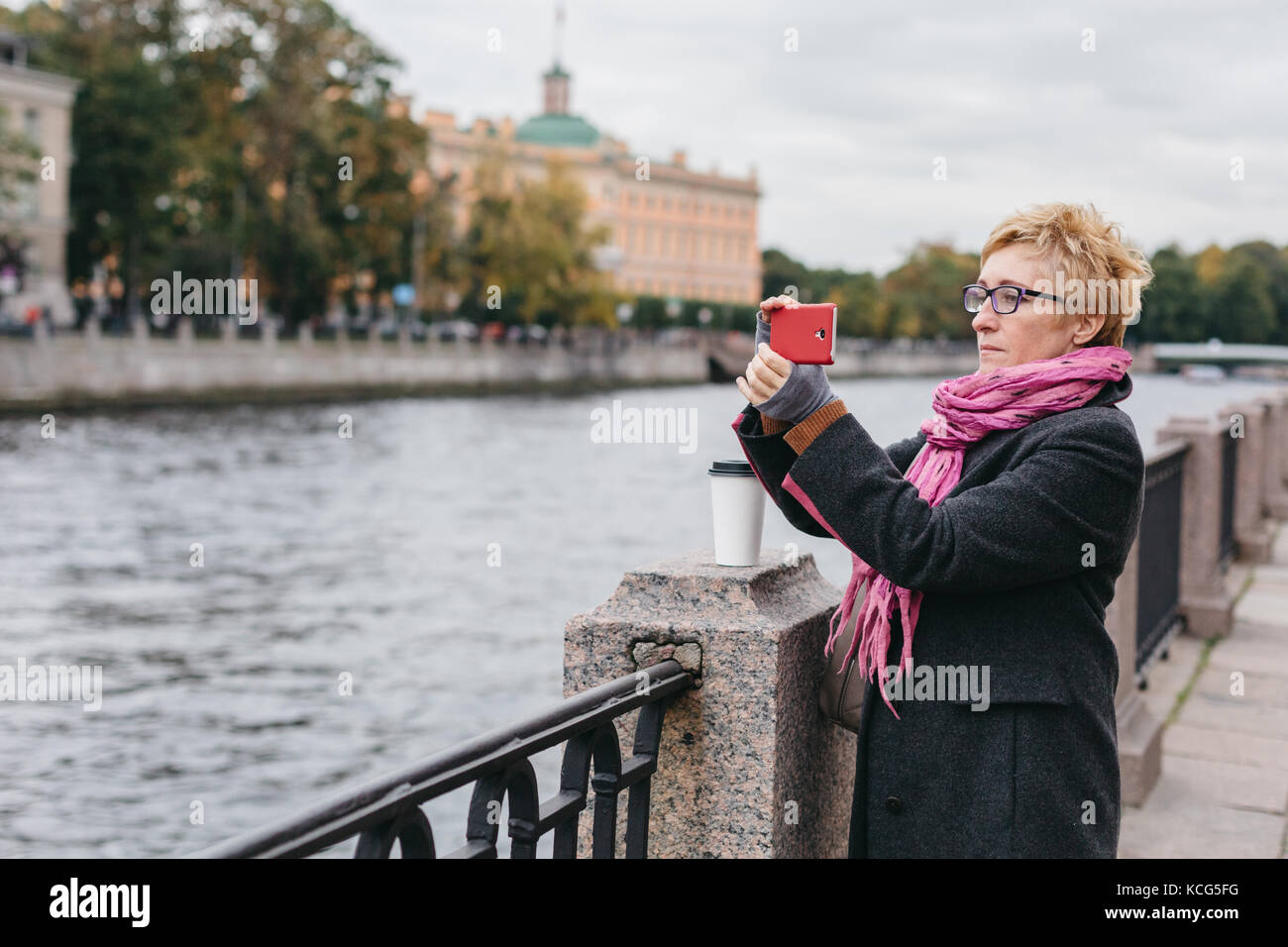 Woman taking shots on waterfront Stock Photo - Alamy