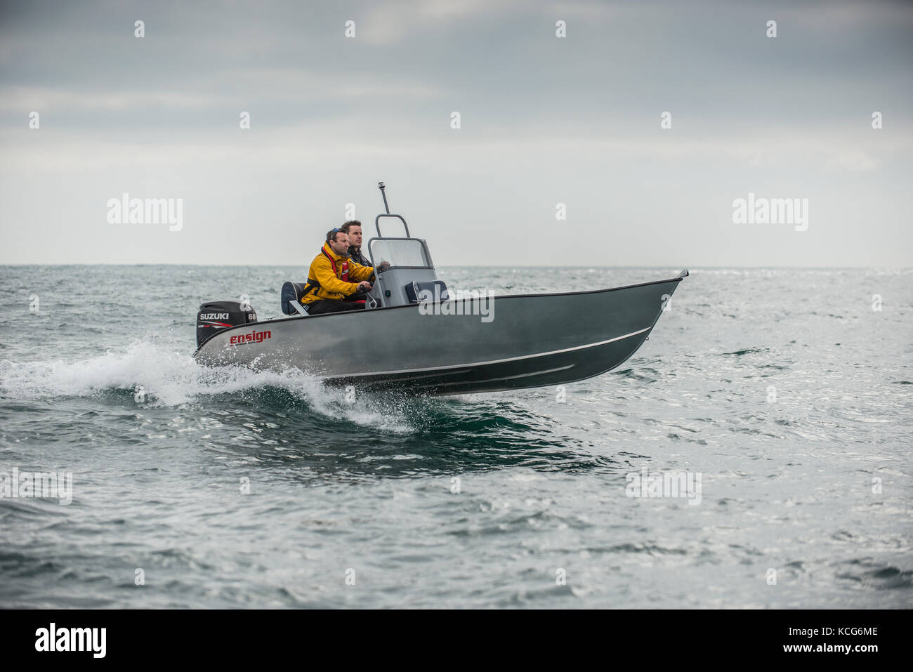An aluminium speed boat with two male occupants on the sea off the ...
